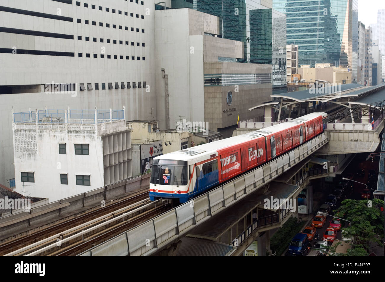 Skytrain leaving Sala Daeng Station with Silom Buildings at the ...