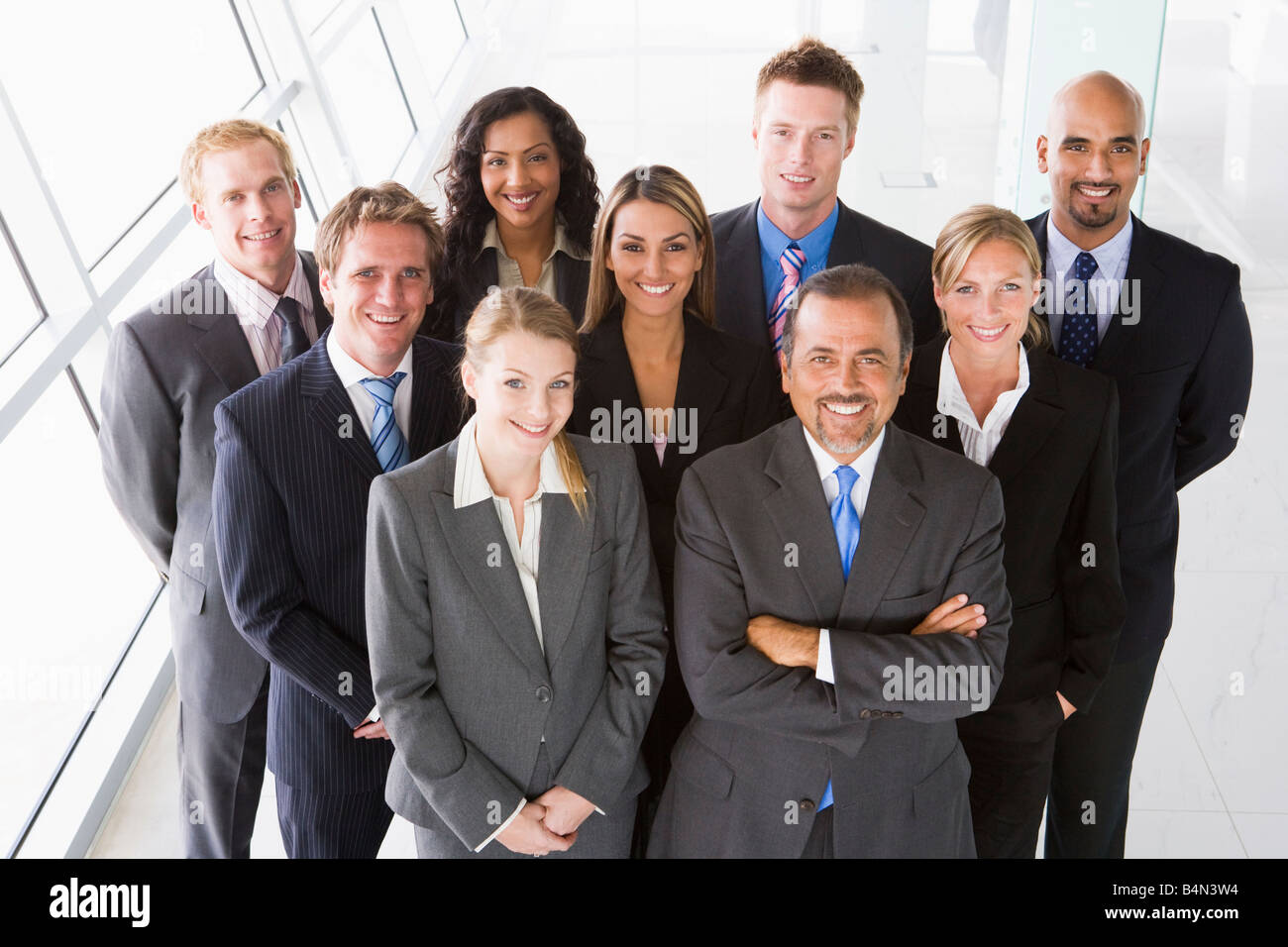 Group of co-workers standing in office space smiling (high key Stock ...