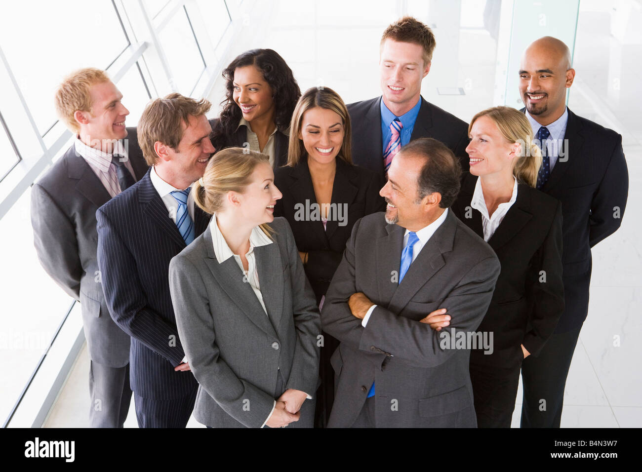 Group of co-workers standing in office space smiling (high key Stock ...