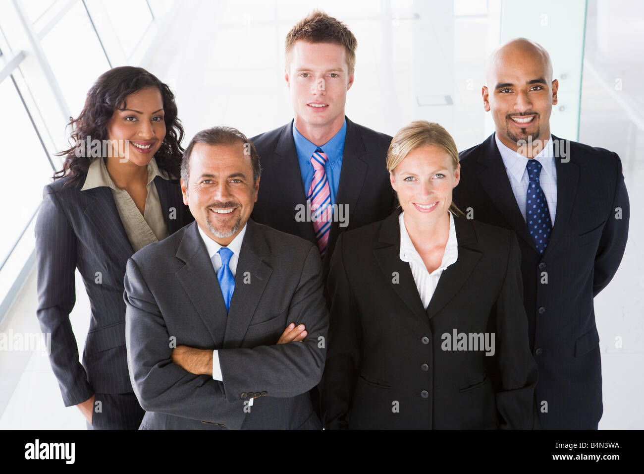 Group of co-workers standing in office space smiling (high key Stock ...