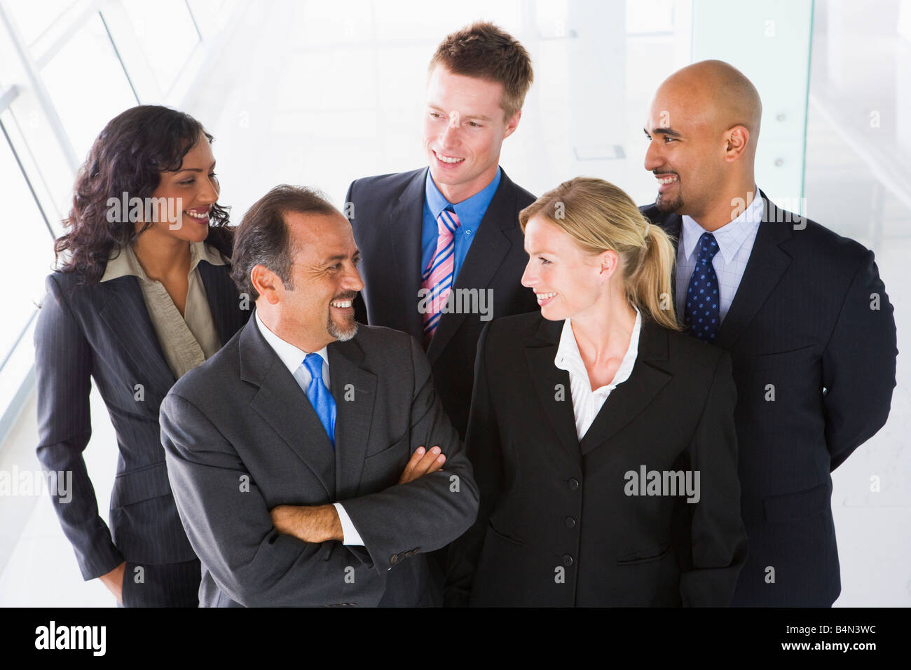 Group of co-workers standing in office space smiling (high key Stock ...