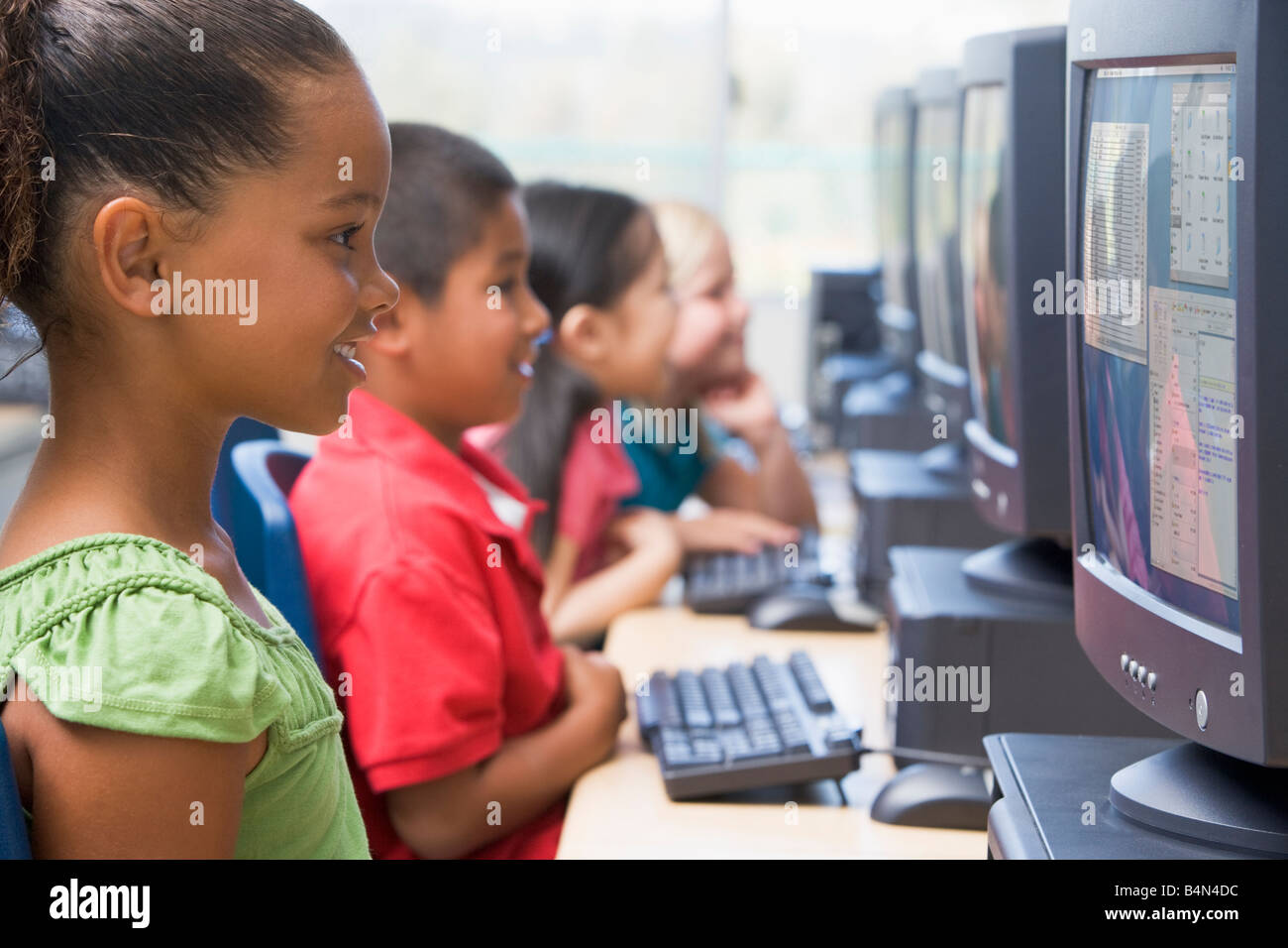 Four children at computer terminals (depth of focus/high key Stock ...