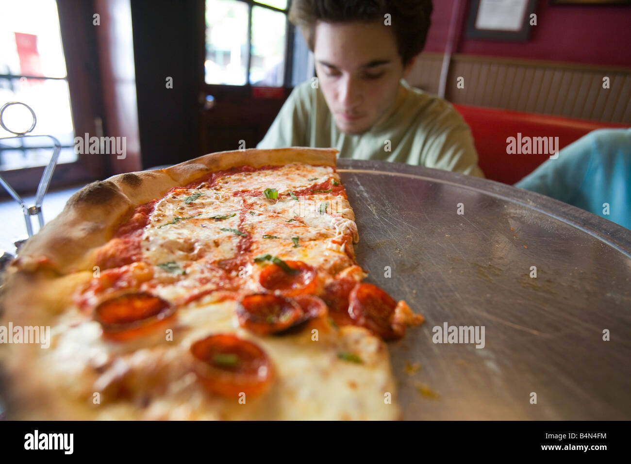 Young man eating pizza in a restaurant Stock Photo - Alamy