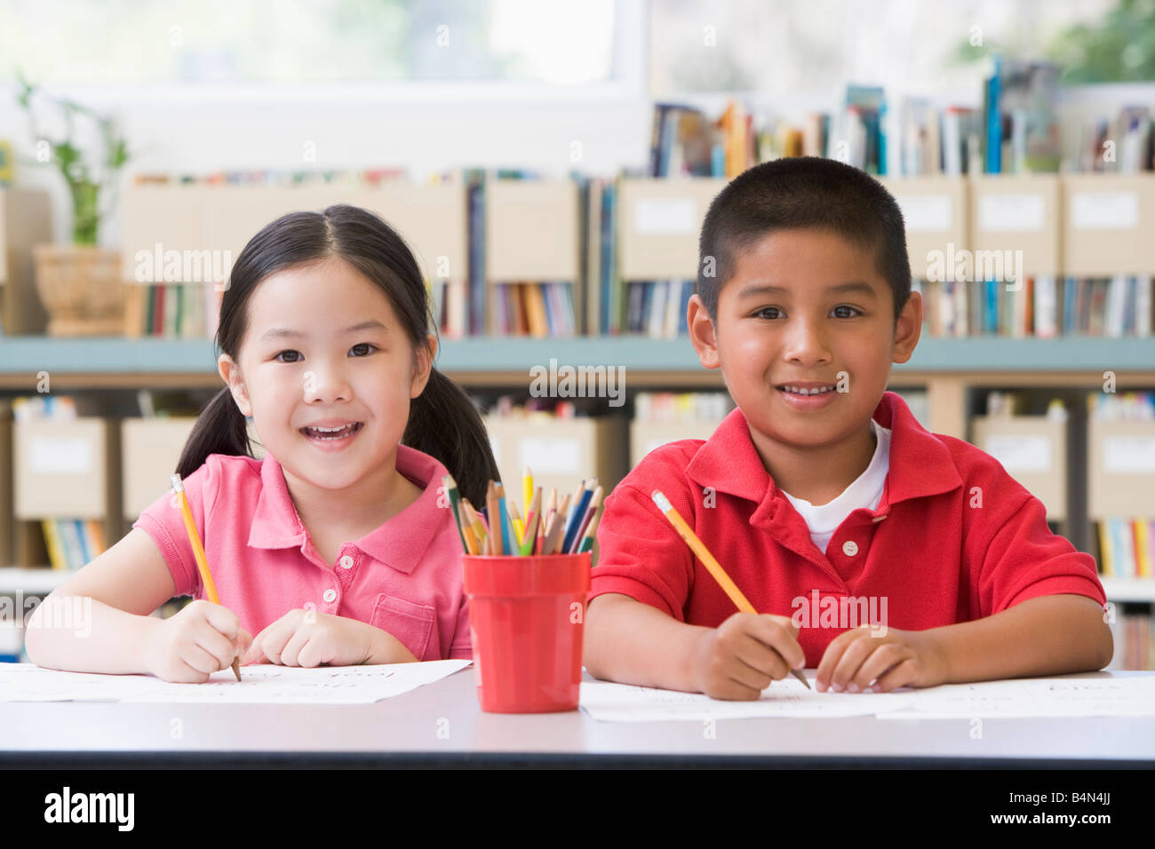 Two students in class writing Stock Photo - Alamy