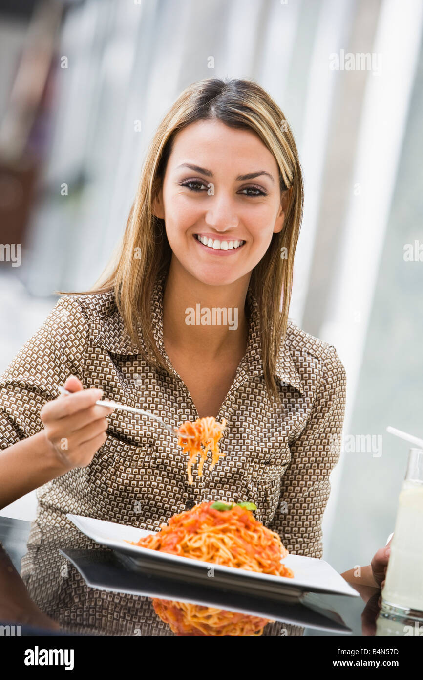 Woman at restaurant eating spaghetti and smiling (selective focus Stock ...
