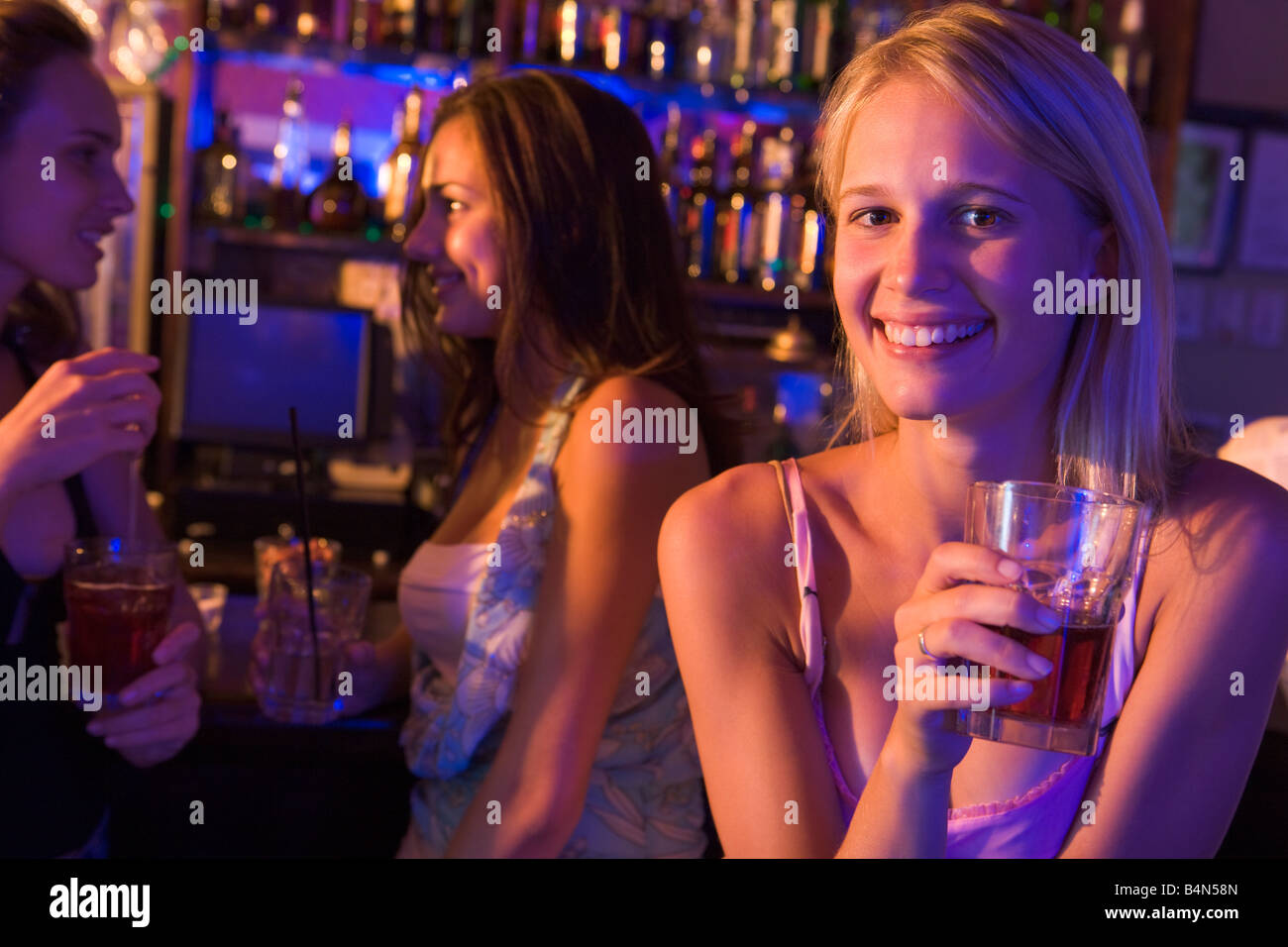 Young woman in a bar with friends Stock Photo - Alamy