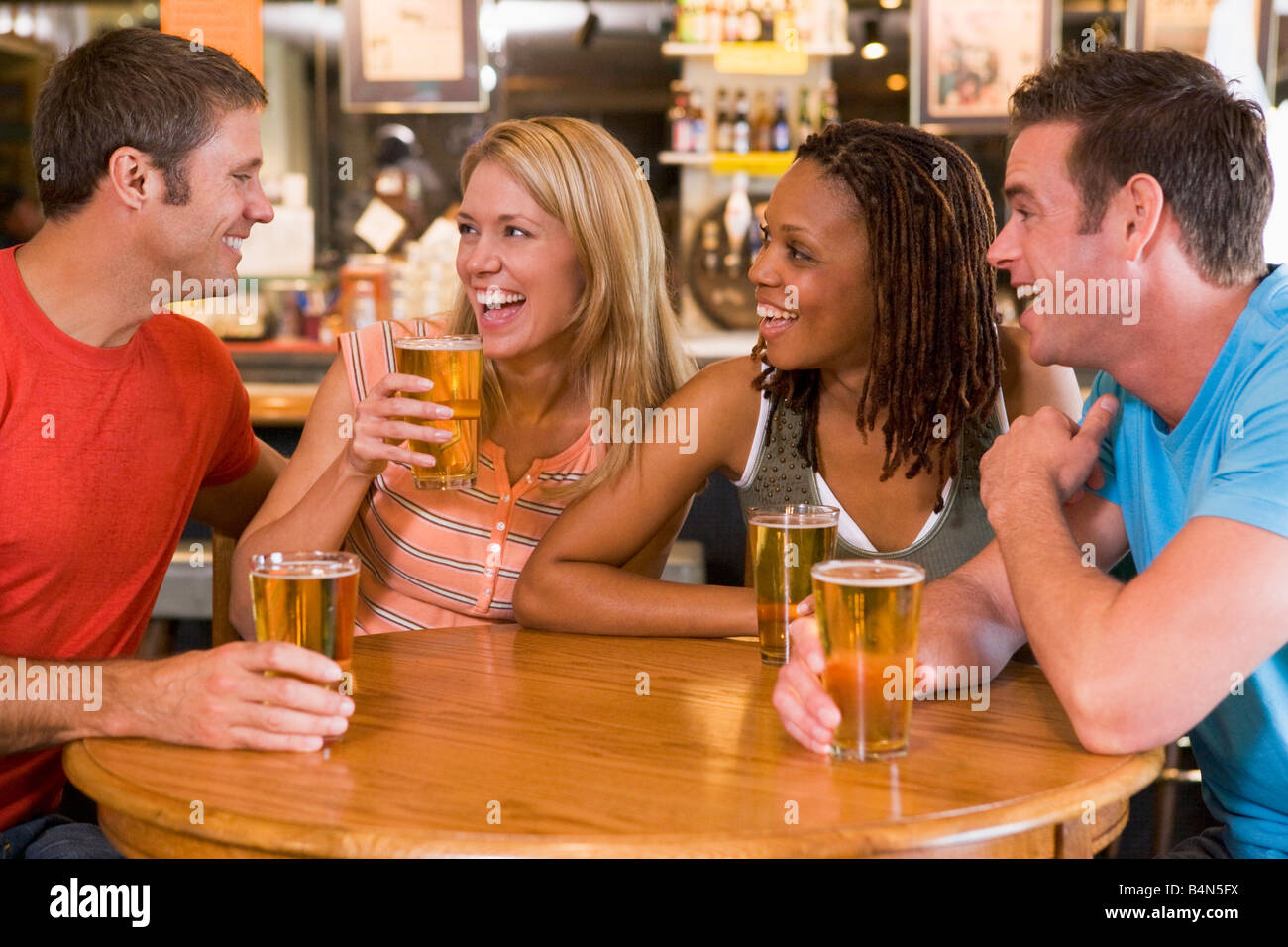 Two couples having beer together Stock Photo - Alamy