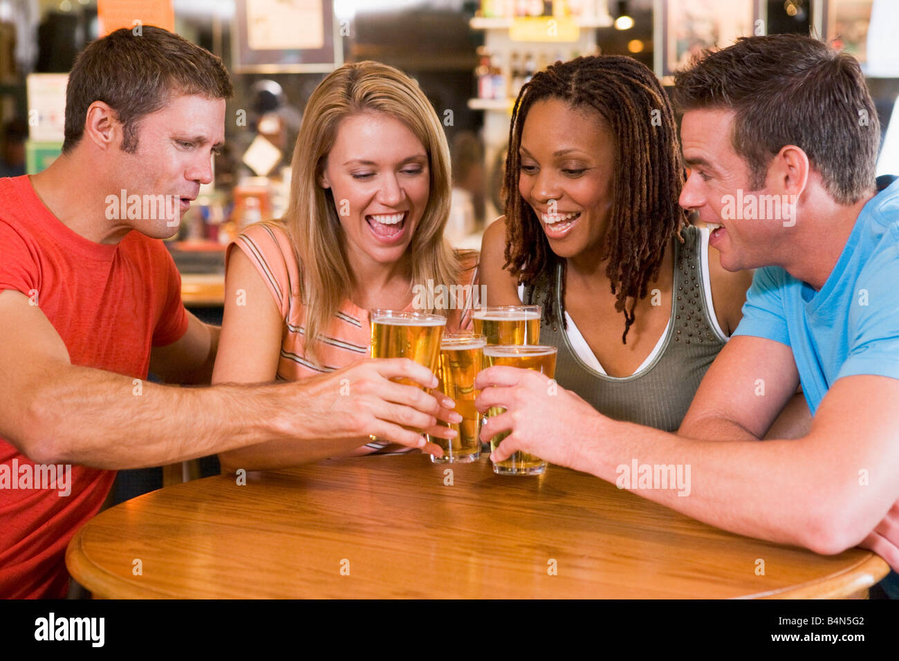 Two couples having beer together Stock Photo - Alamy