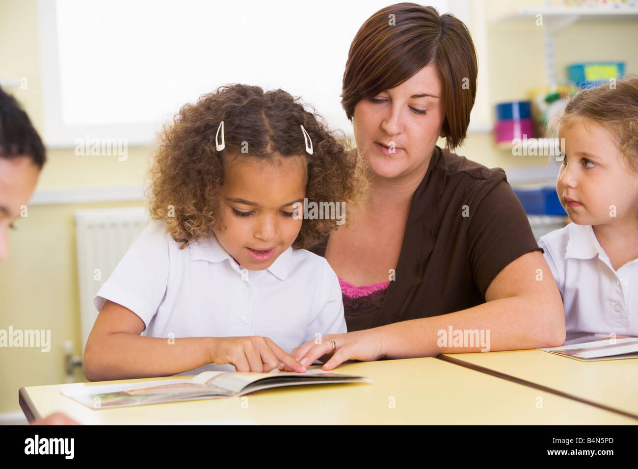 Teacher students reading together table hi-res stock photography and ...