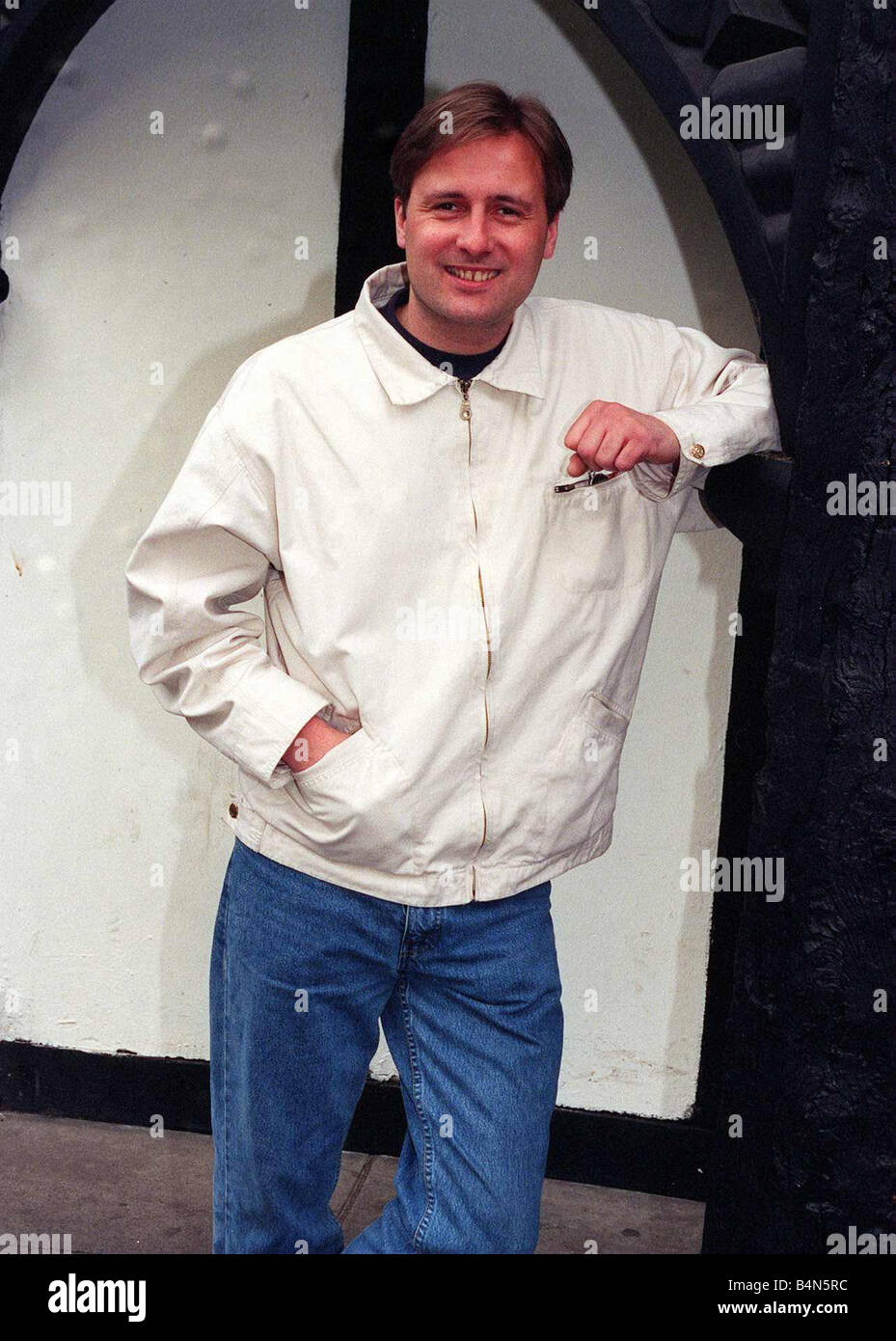 Gary Webster actor leaning against wall white jacket denims clenched ...