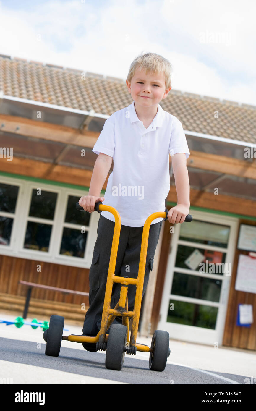 Student outside school on tricycle scooter Stock Photo - Alamy