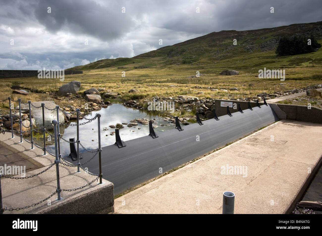 Tilting gate weir and dam across river Afon Eigiau controlling water ...