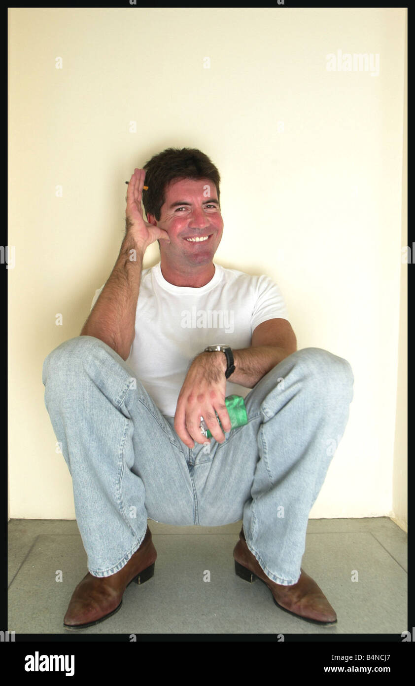 Pop Idol judge Simon Cowell poses for photographers smoking a cigarette ...