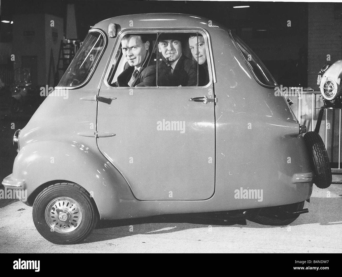 Three friends sit in a three wheeler Scootacar at the Earls Court Cycle ...