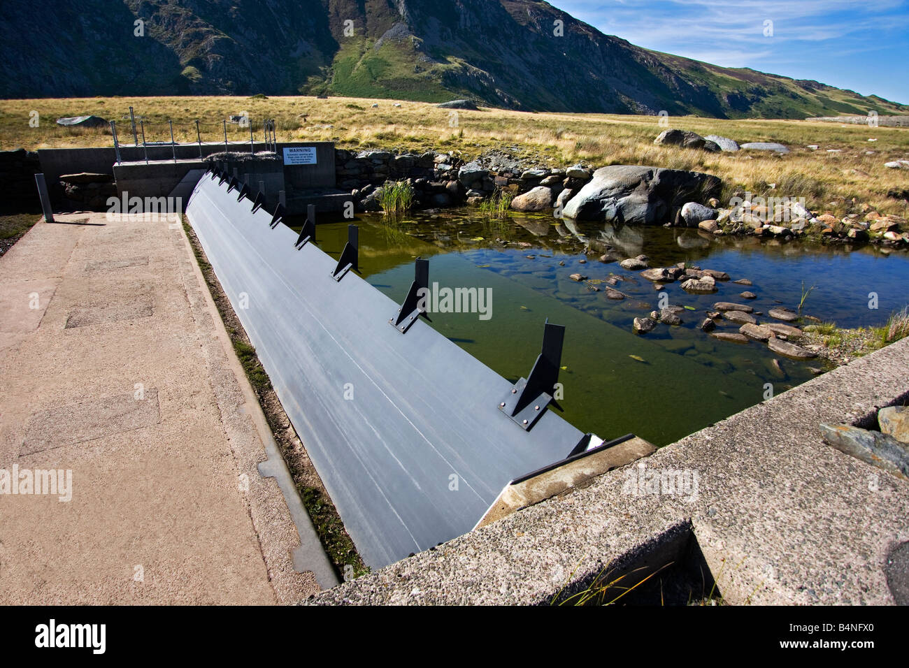 Tilting gate weir and dam across river Afon Eigiau controlling water ...