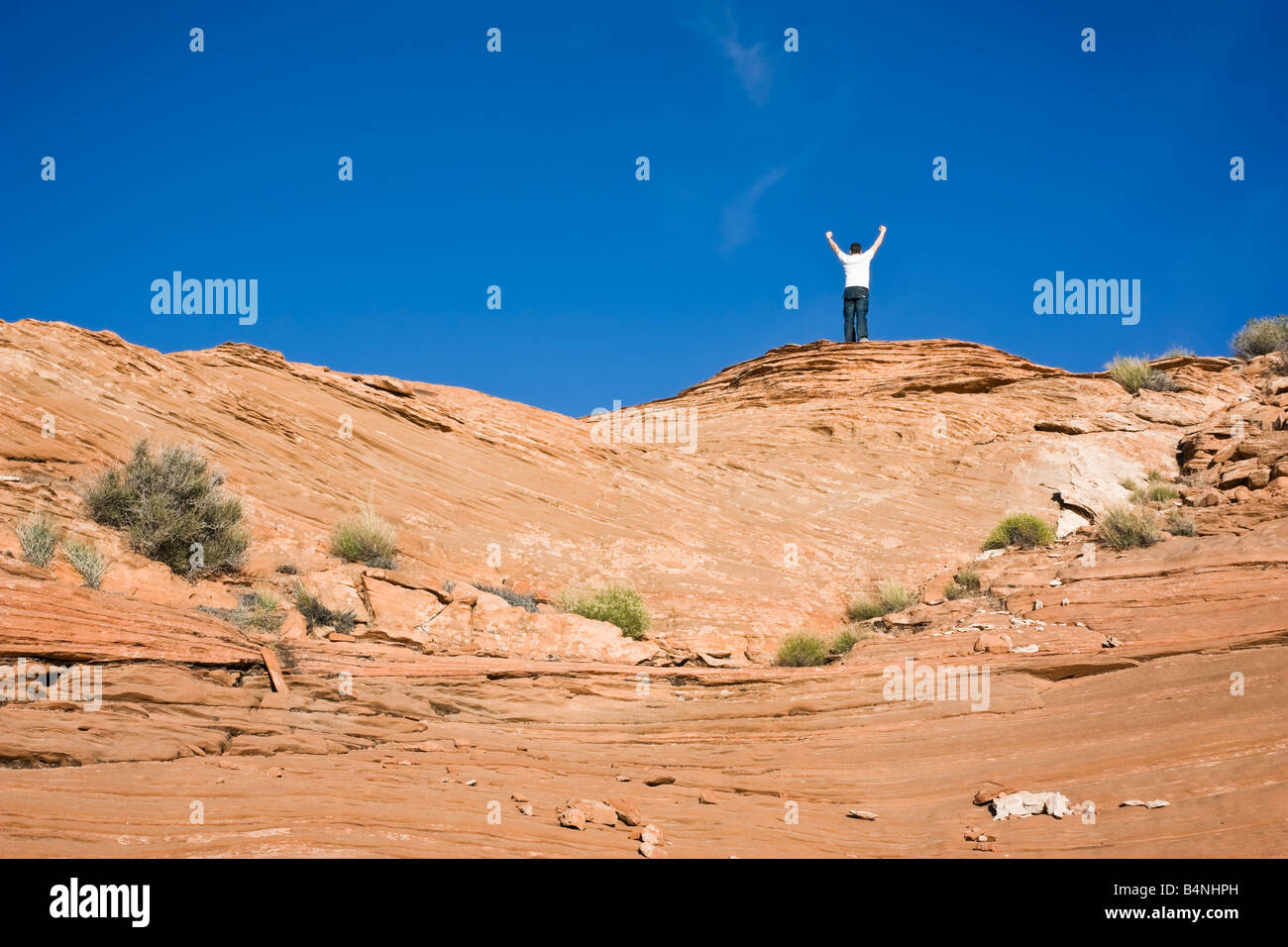 Man standing arms up on top of a hill Stock Photo - Alamy