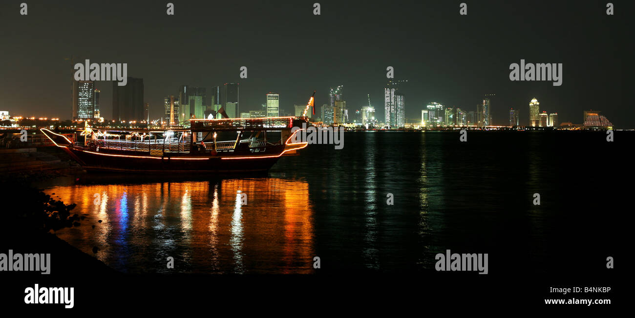 A view across Doha Bay Qatar at night with an illuminated pleasure trip ...