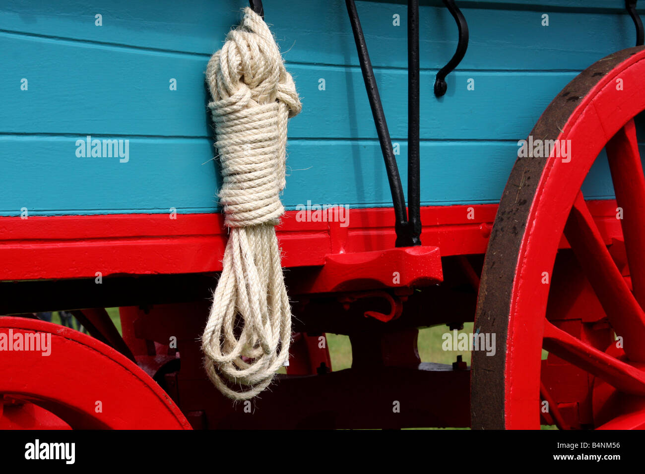 Detail of blue and red farm wagon with coiled rope Stock Photo - Alamy