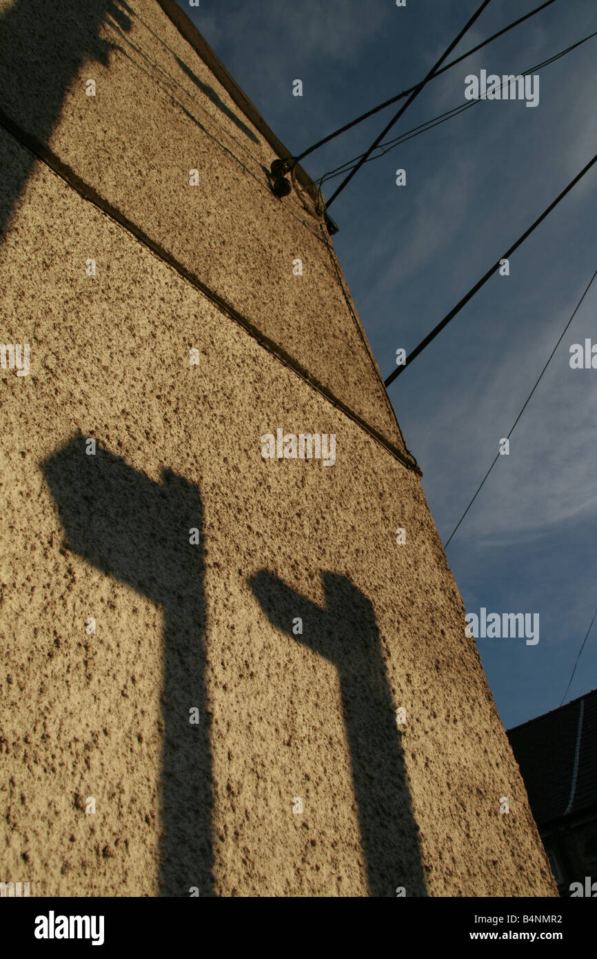 two footpath signs shadow on house wall in sun Stock Photo - Alamy