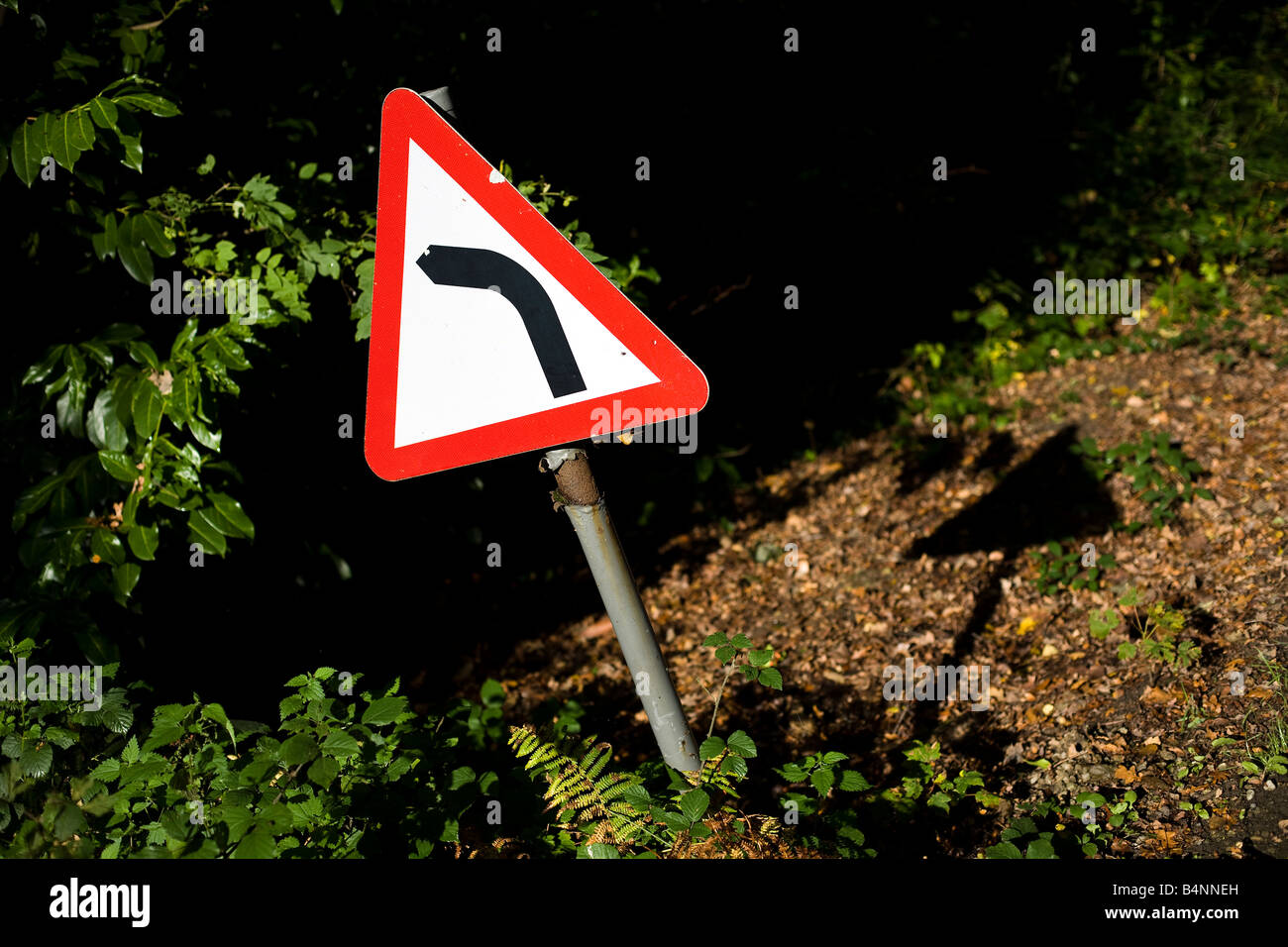 A road sign warning of a bend ahead Stock Photo - Alamy