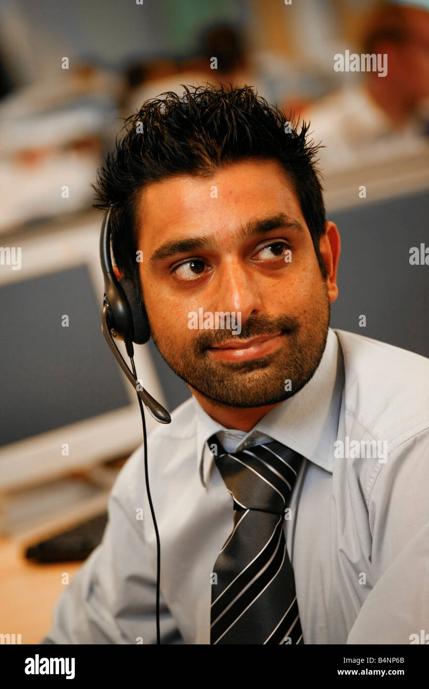 Call centre operator using a headset to answer the telephone Service ...