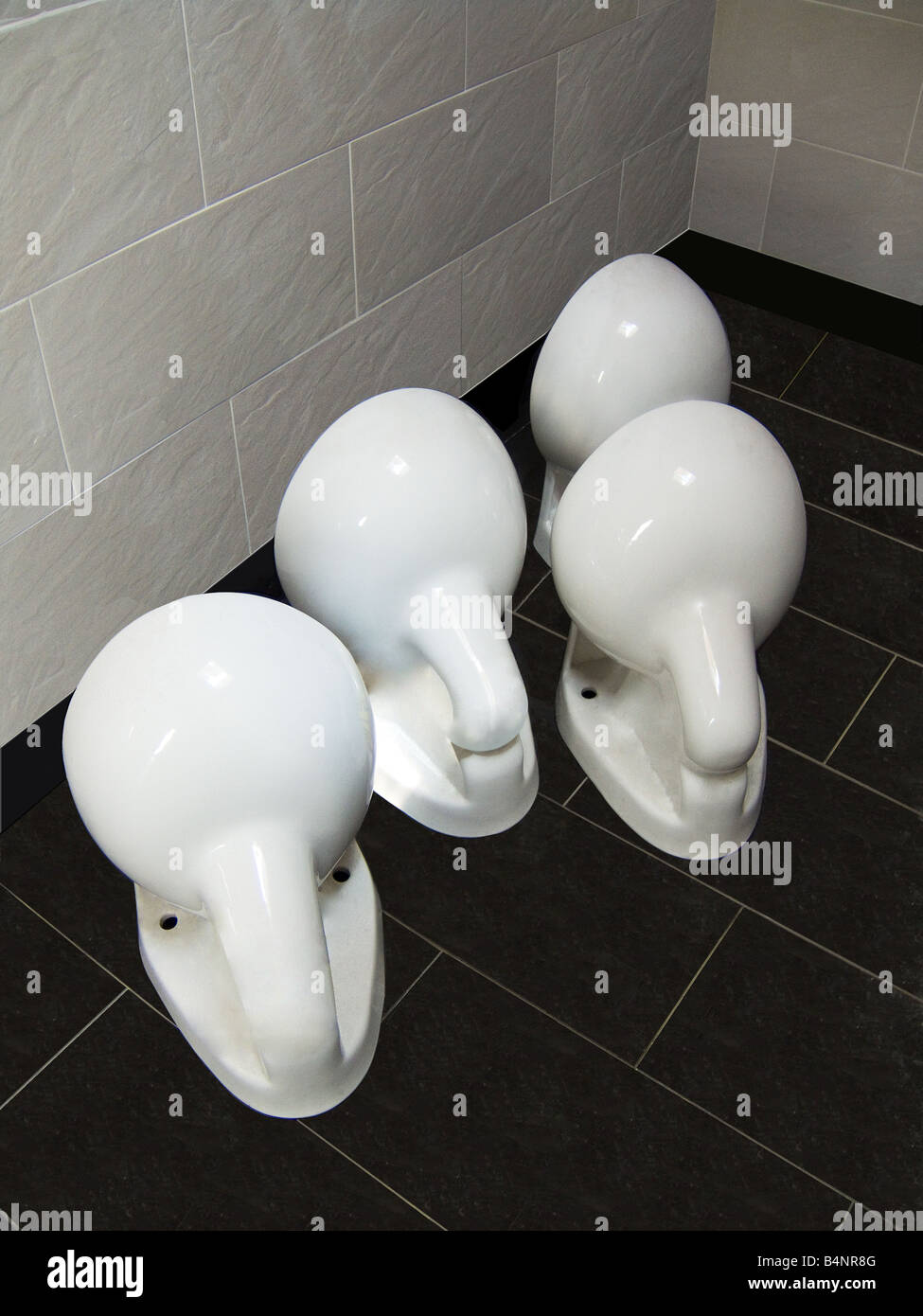 Four urinals ready to be installed in a male toilets - a surreal group ...