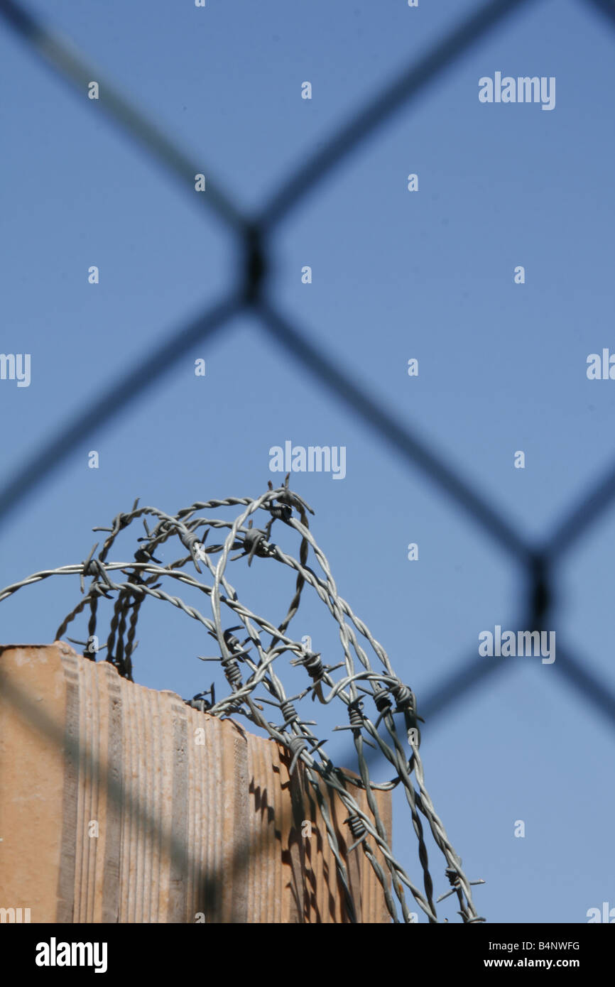 tangled barbed wire fence against blue sky Stock Photo - Alamy