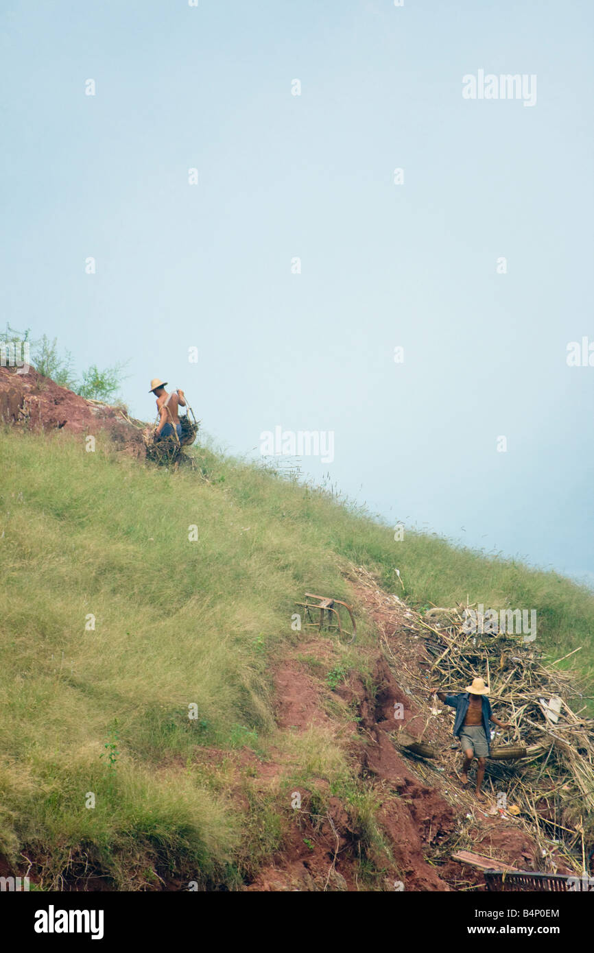 Chinese men carry litter in baskets up a hill Stock Photo - Alamy