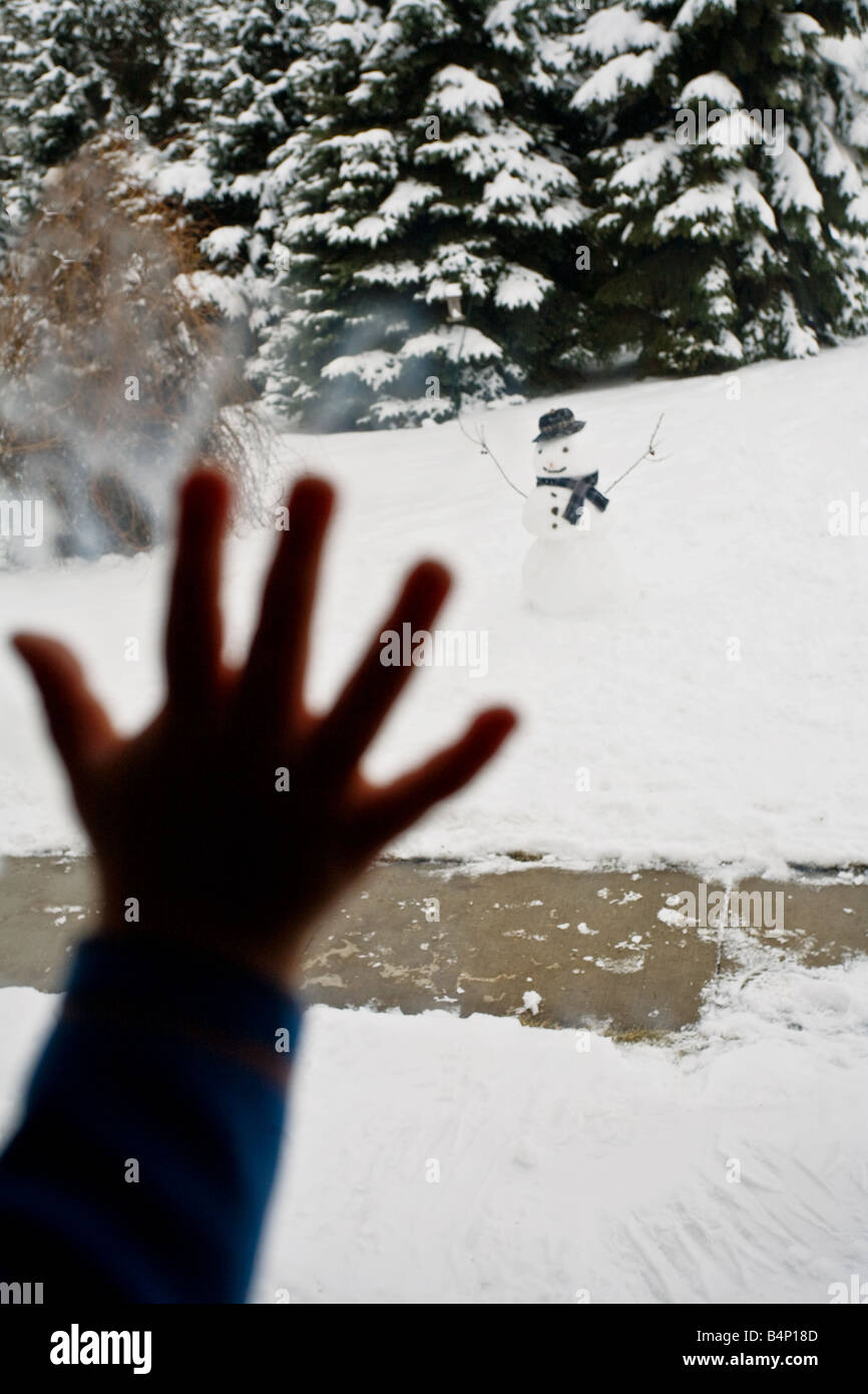 A child hand on the window looking out at a snowman Stock Photo - Alamy