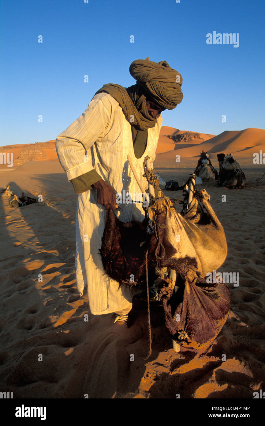 Algeria Djanet Men of Tuareg tribe Camel caravan Goatskin filled with ...