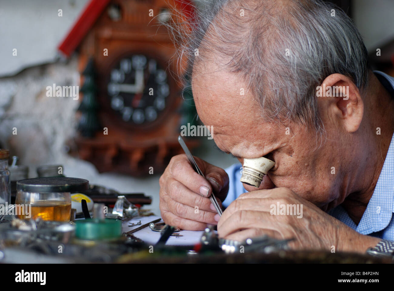 Senior man with magnifier on eye repairing watch Stock Photo - Alamy