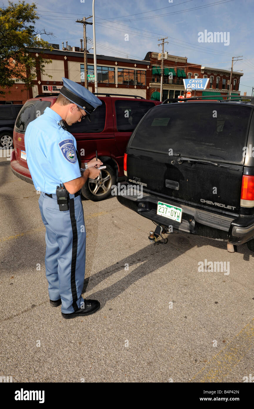 Police officer writes a ticket for parking violation Stock Photo - Alamy