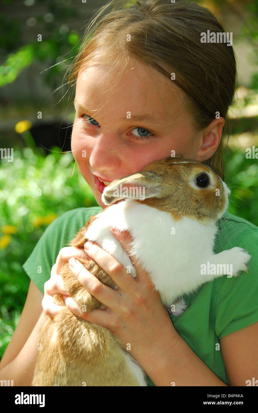 Portrait of a young girl holding a bunny outside Stock Photo - Alamy