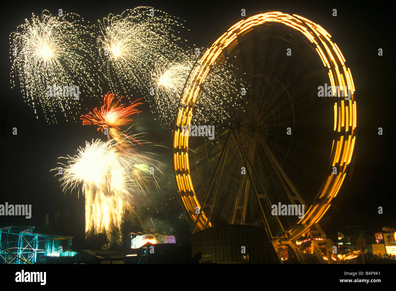 display of fireworks and big wheel at a fun fair Stock Photo - Alamy