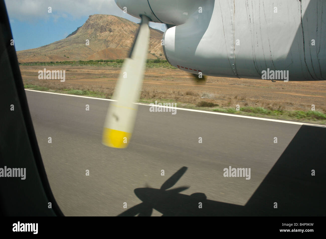 Propellor engine and its shadow on the runway seen from the airplane ...