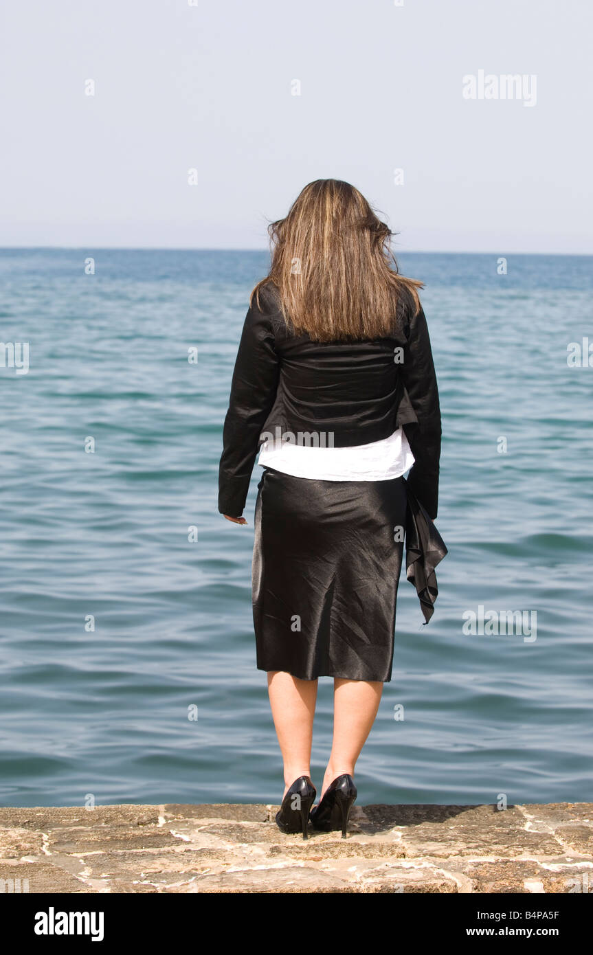 Rear view of a woman standing by the sea Stock Photo - Alamy