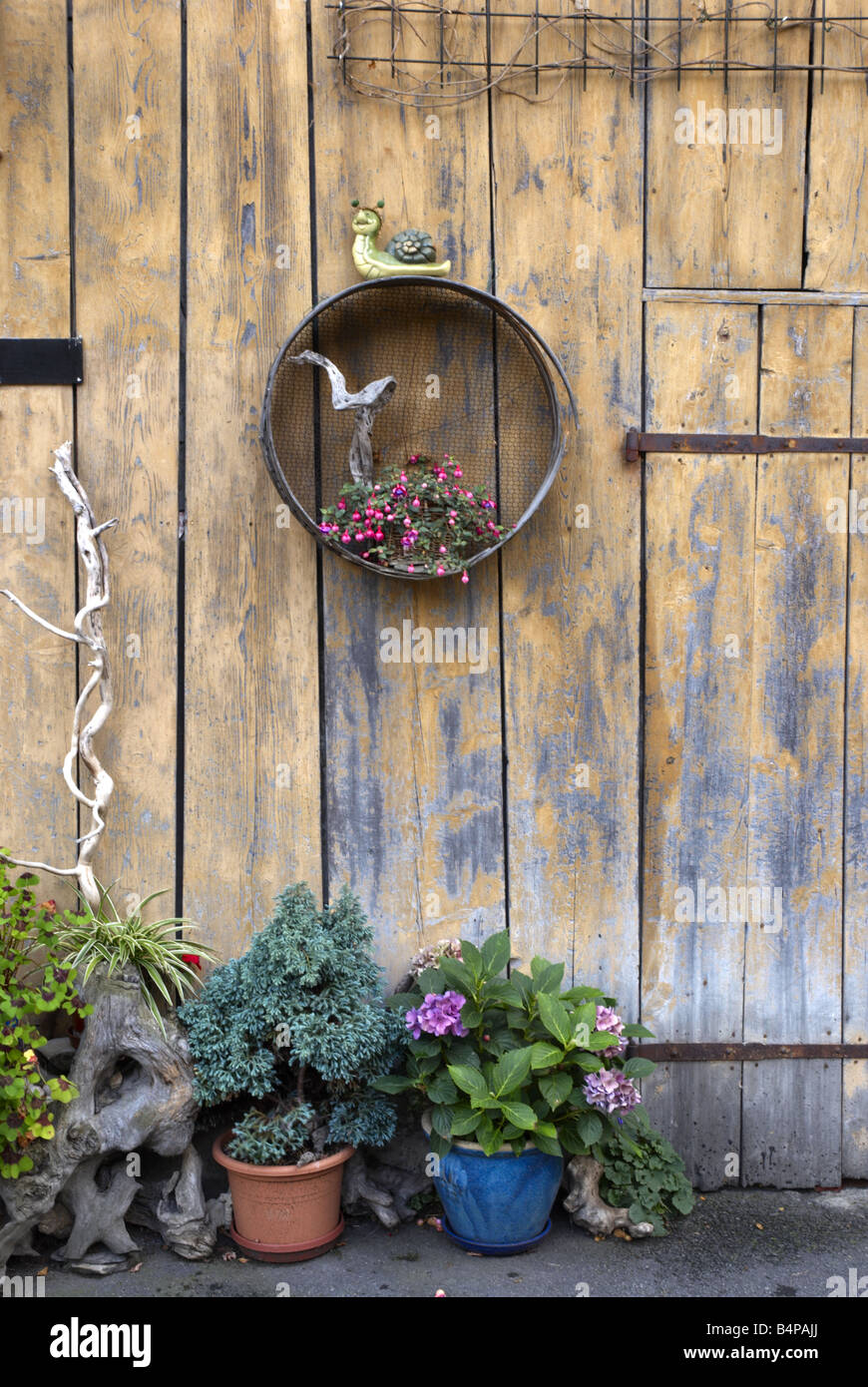 Wooden doorway with planting and sieve hanging on door Stock Photo - Alamy