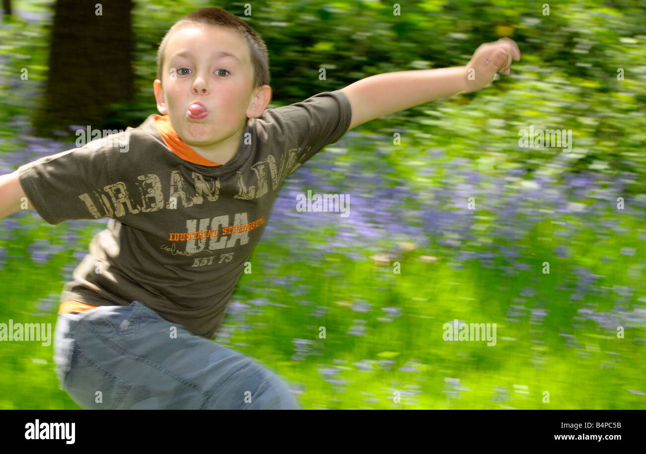 A young boy jumping and poking his tongue out Stock Photo - Alamy