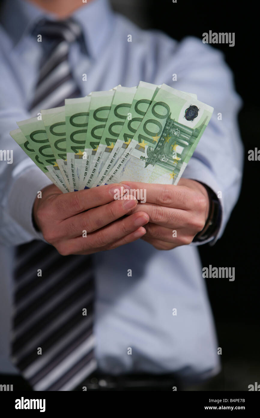 Businessman offering money, mid section Stock Photo - Alamy