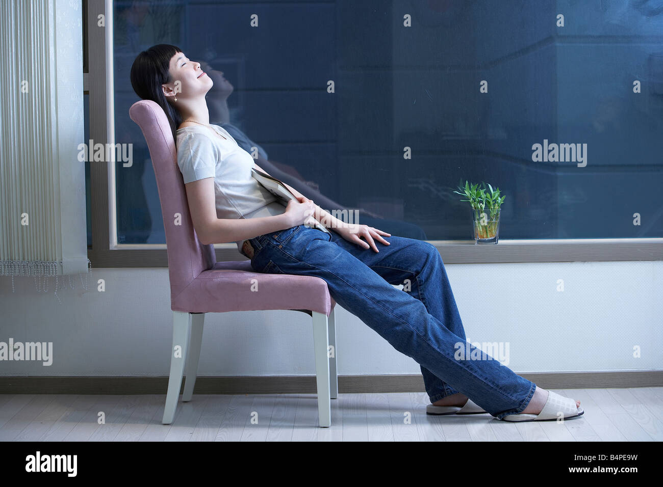 Young woman relaxing on chair Stock Photo - Alamy