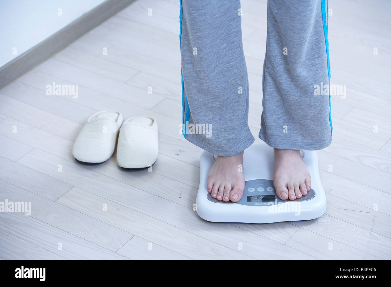 Woman standing on weighing scale, low section Stock Photo - Alamy