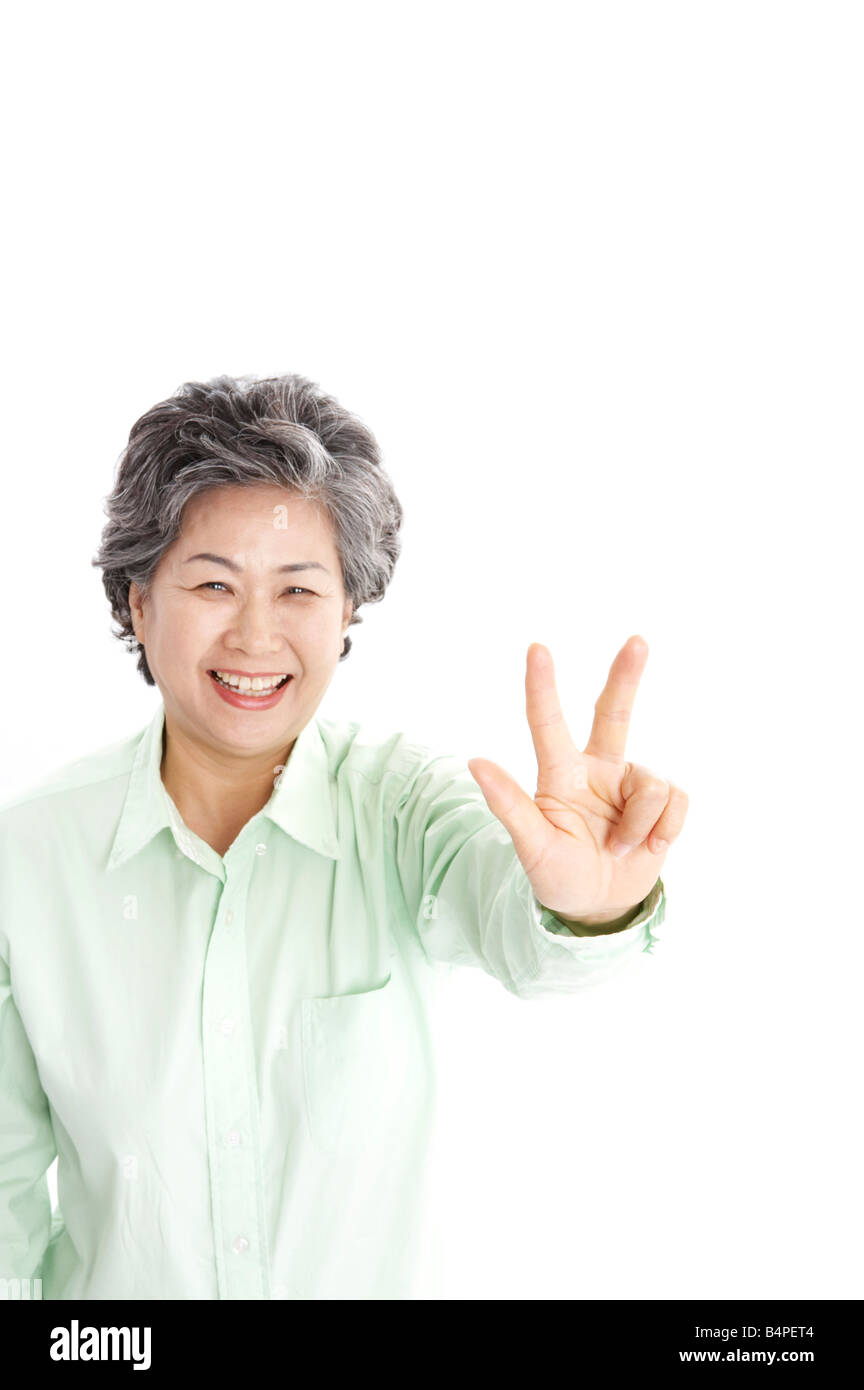 Mature woman making peace sign hi-res stock photography and images - Alamy