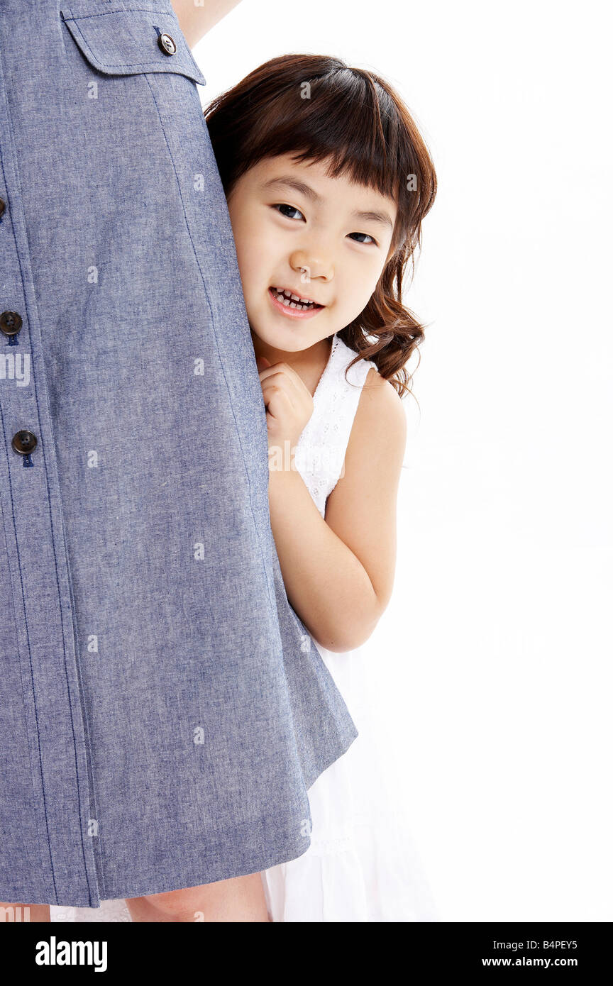 Portrait of a girl hiding behind mother Stock Photo - Alamy
