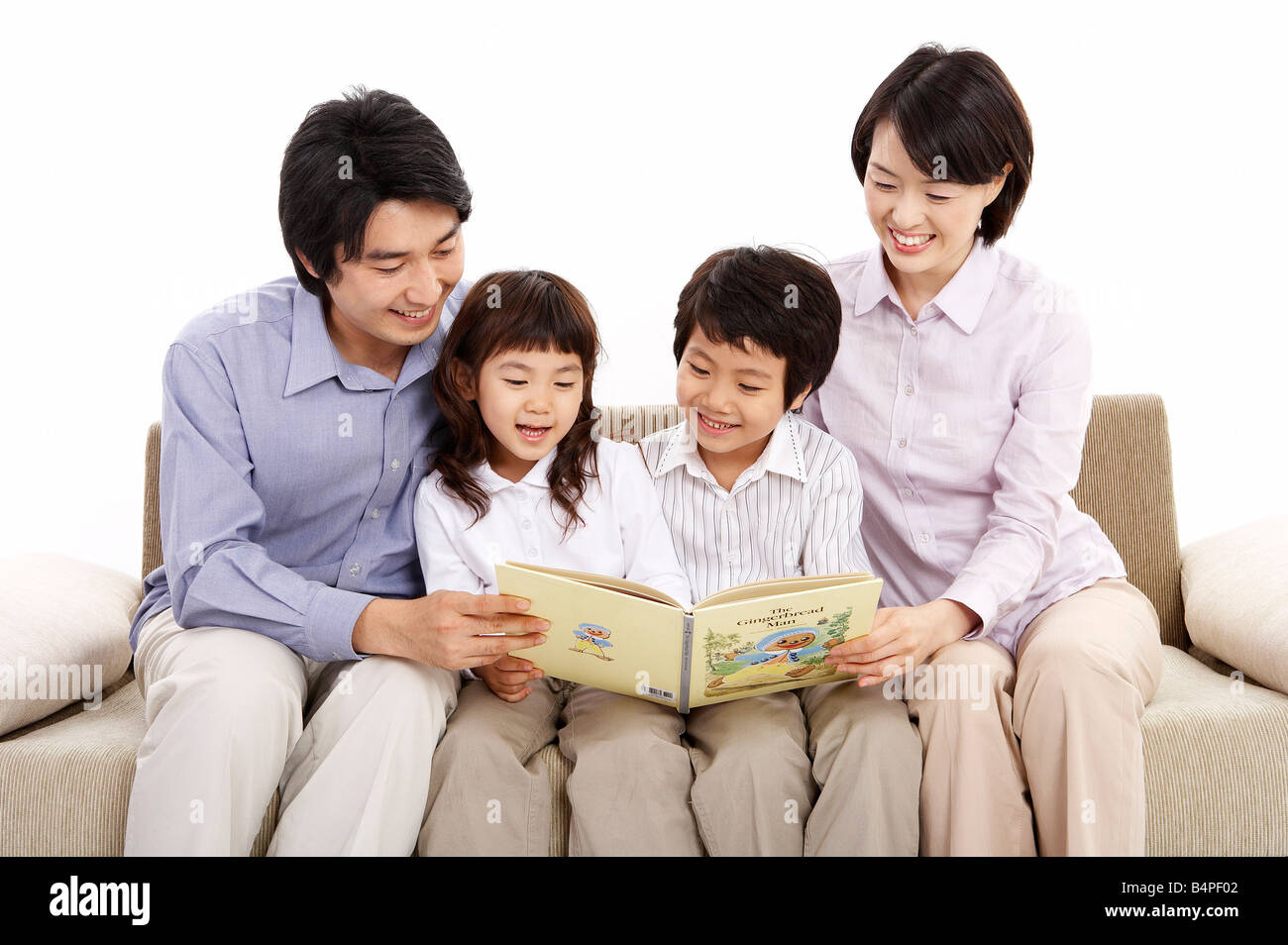Parents with children reading book Stock Photo - Alamy