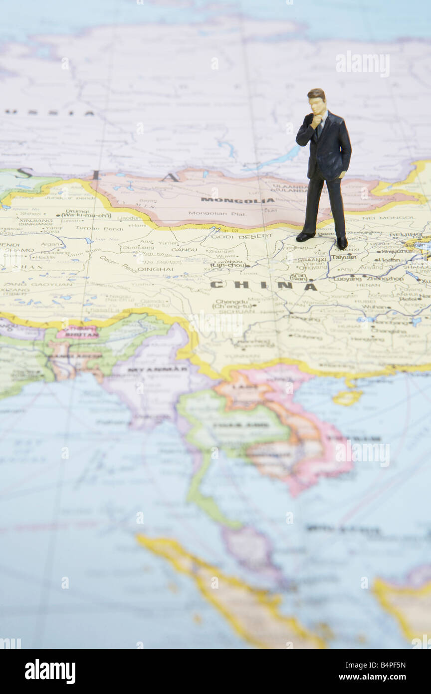 Businessman figurine standing over world map Stock Photo - Alamy