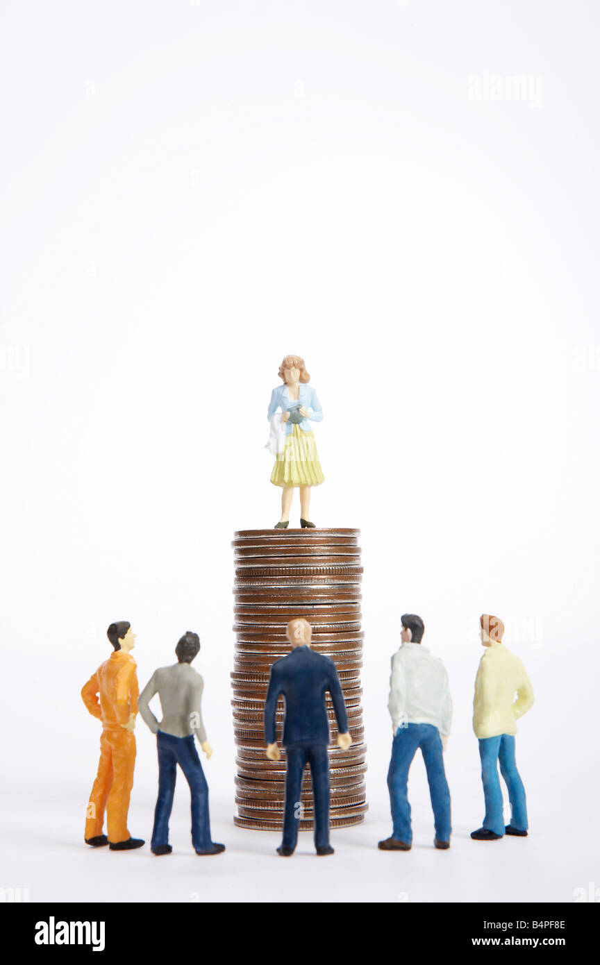 Female figurine standing on stack of coins with male figurines around ...