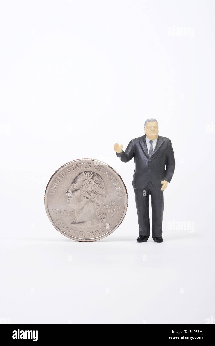 Male figurine standing by single coin Stock Photo - Alamy