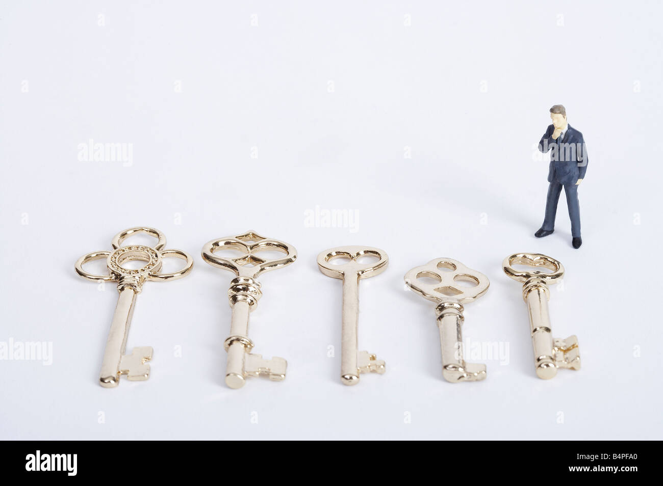 Male figurine standing by different shaped keys Stock Photo - Alamy