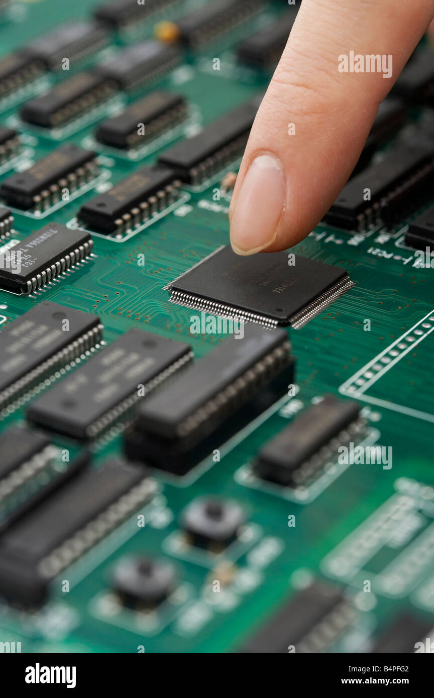 Person touching green circuit board chip Stock Photo - Alamy