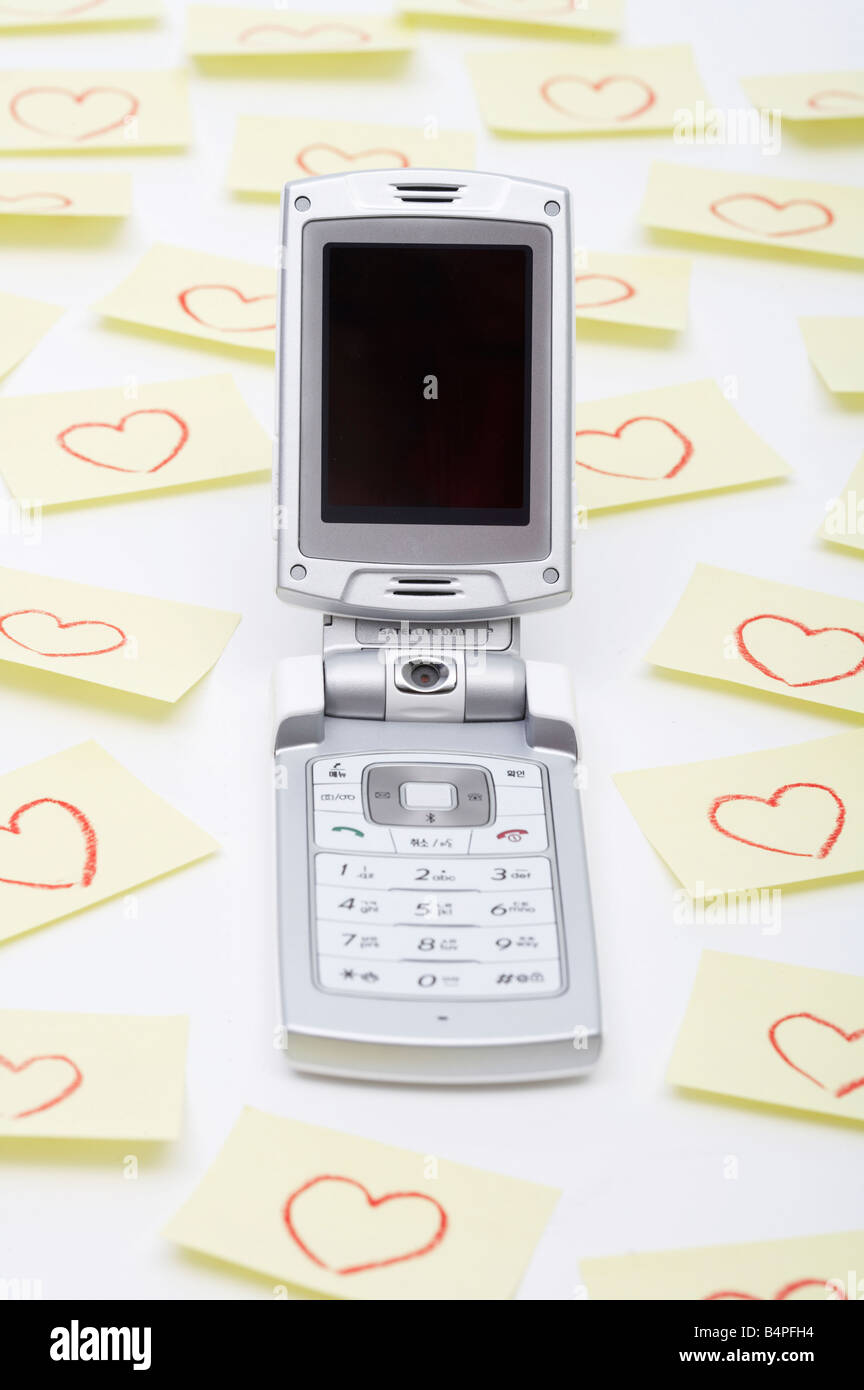 Mobile phone with heart on note against white background Stock Photo ...
